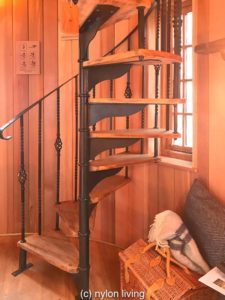 A free standing tree house with a tree house slide